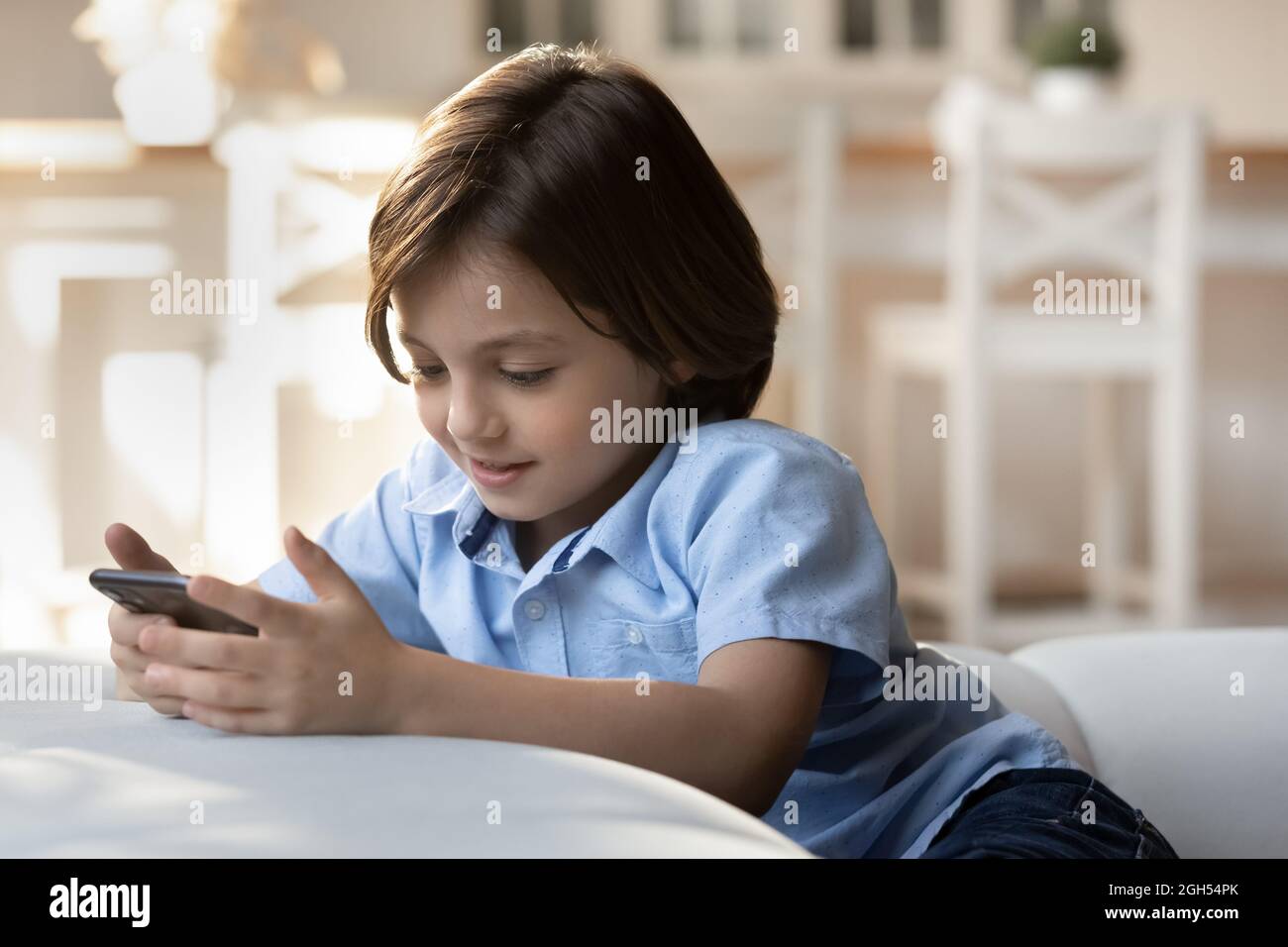 Happy child boy using cellphone applications at home Stock Photo - Alamy