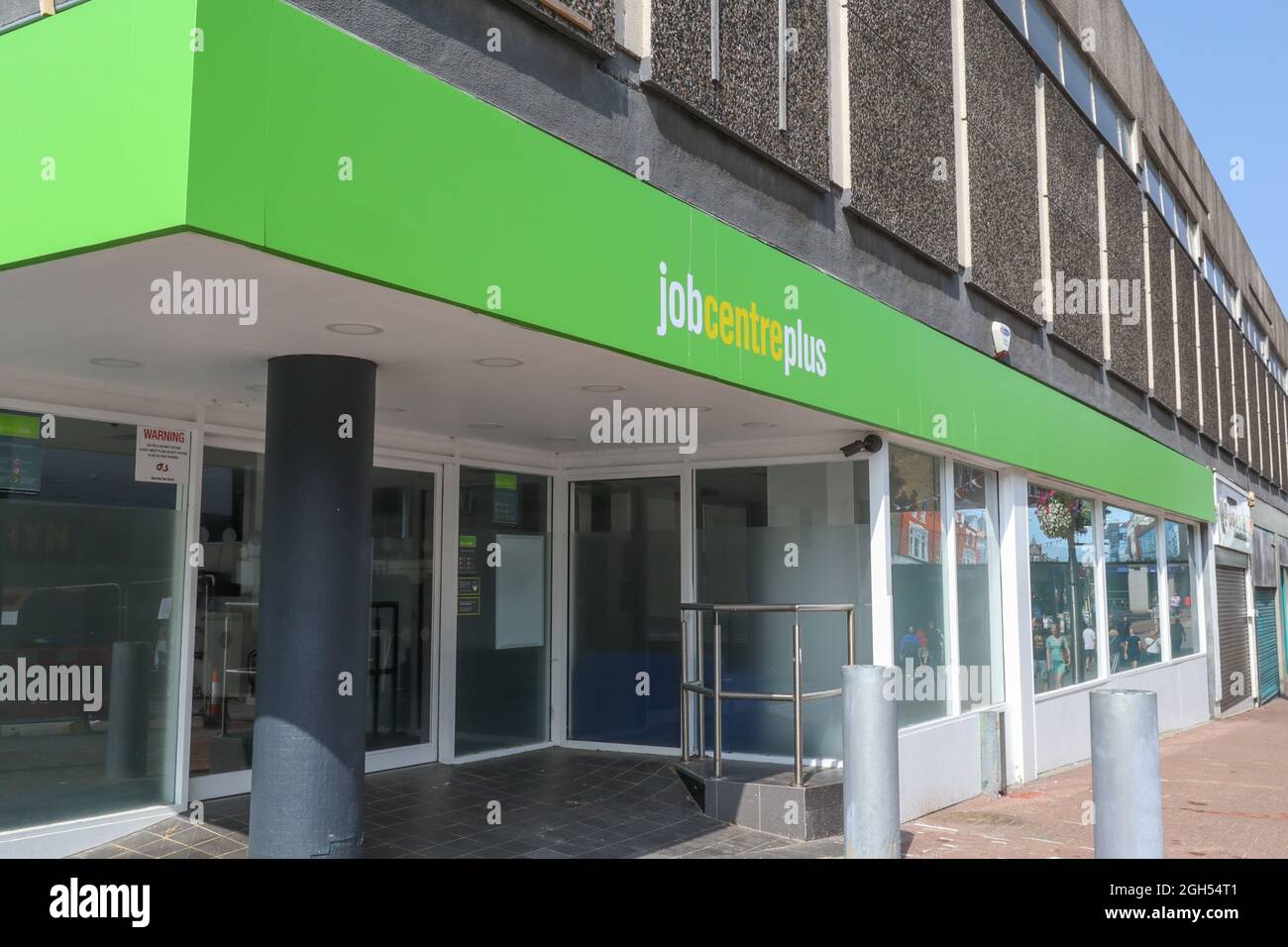 Jobcentre Plus entrance with green signage, glass doors, and ramp ...