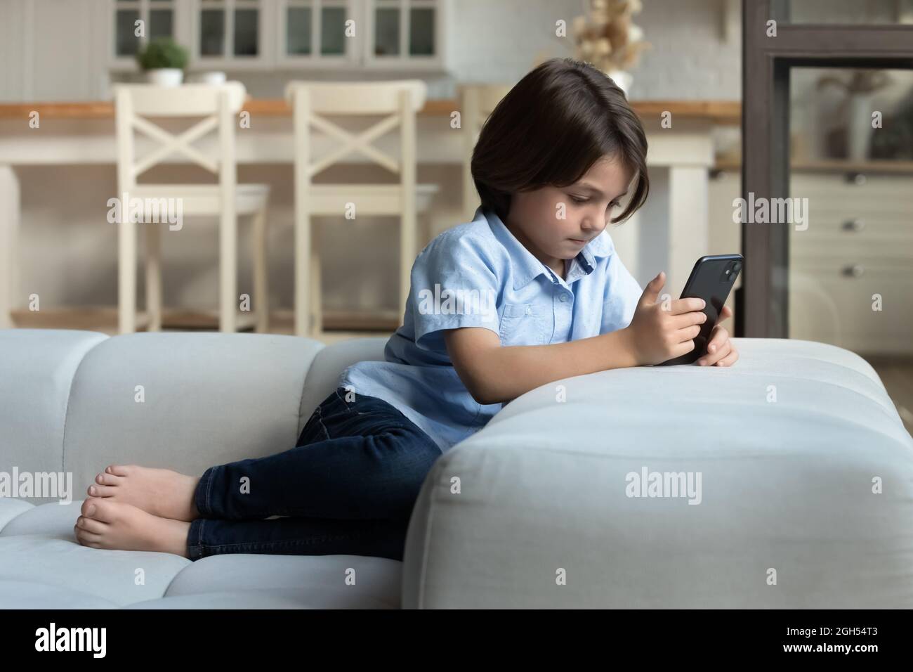 Full length relaxed happy little kid boy using cellphone Stock Photo ...