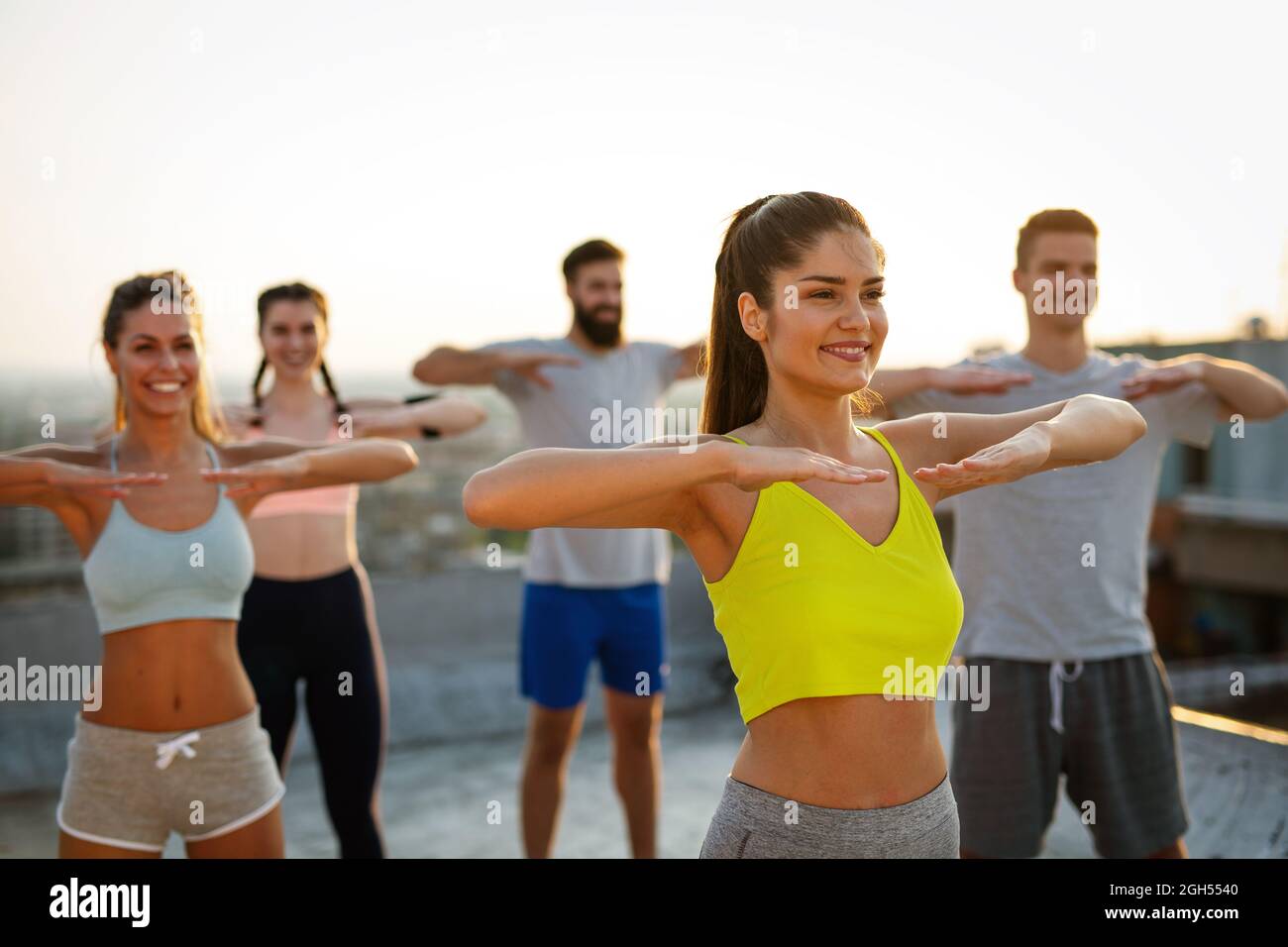 Group of happy fit friends exercising together outdoor Stock Photo - Alamy