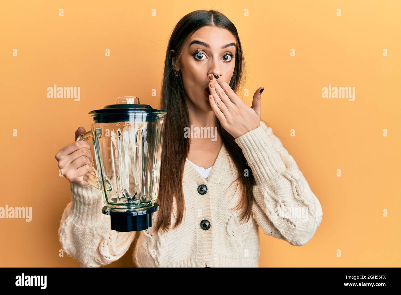 Beautiful brunette young woman holding food processor mixer machine ...