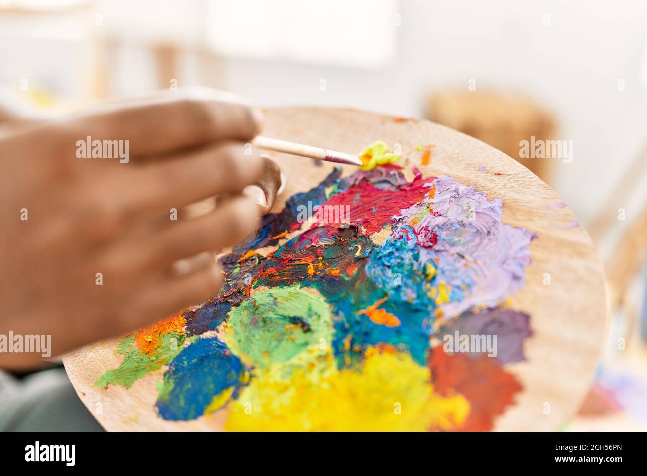 Hand of african american artist man mixing color on palette at art ...