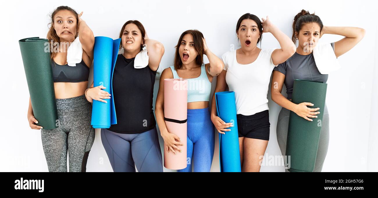 Group of women holding yoga mat standing over isolated background crazy ...