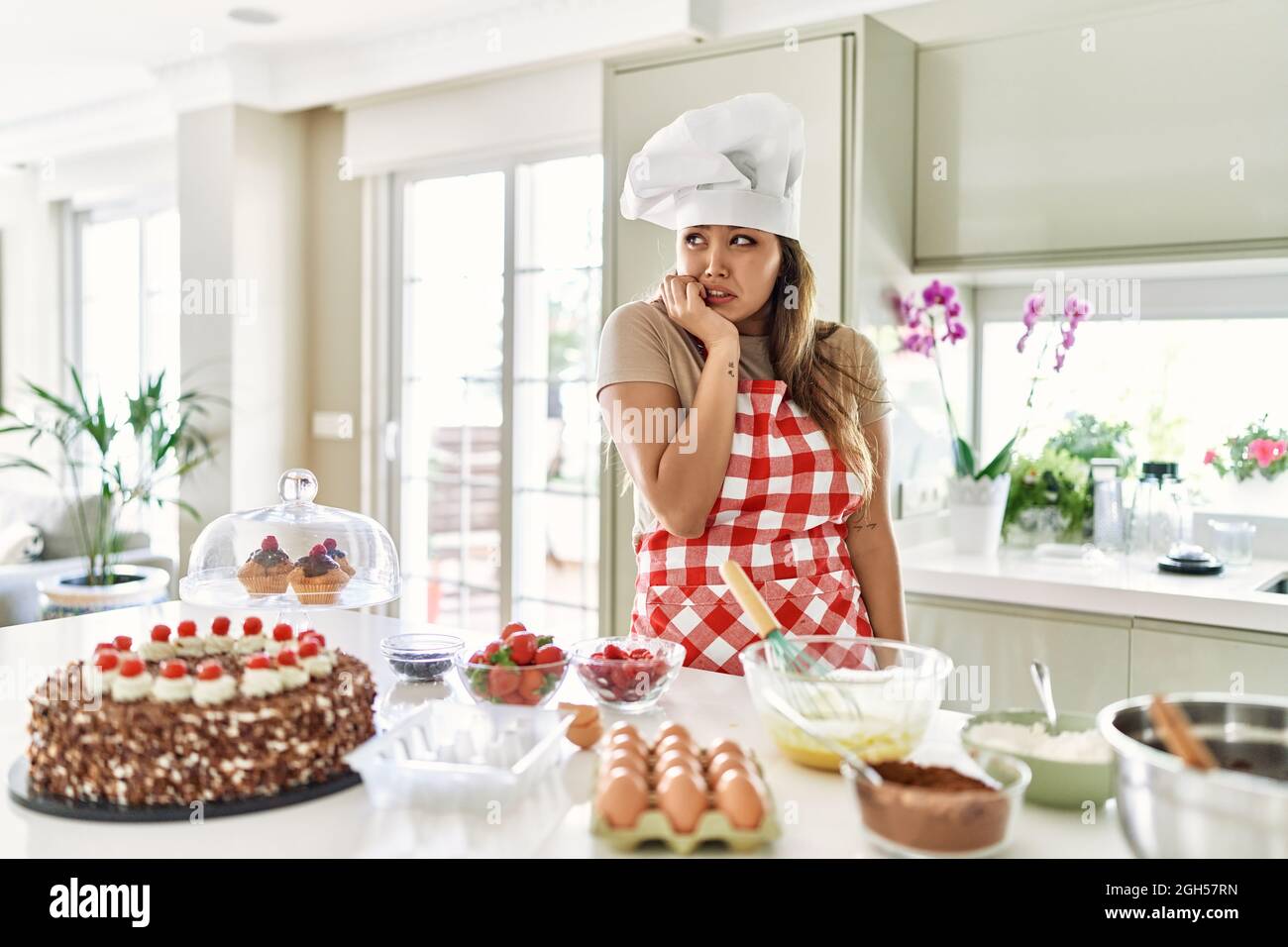 Beautiful young brunette pastry chef woman cooking pastries at the ...