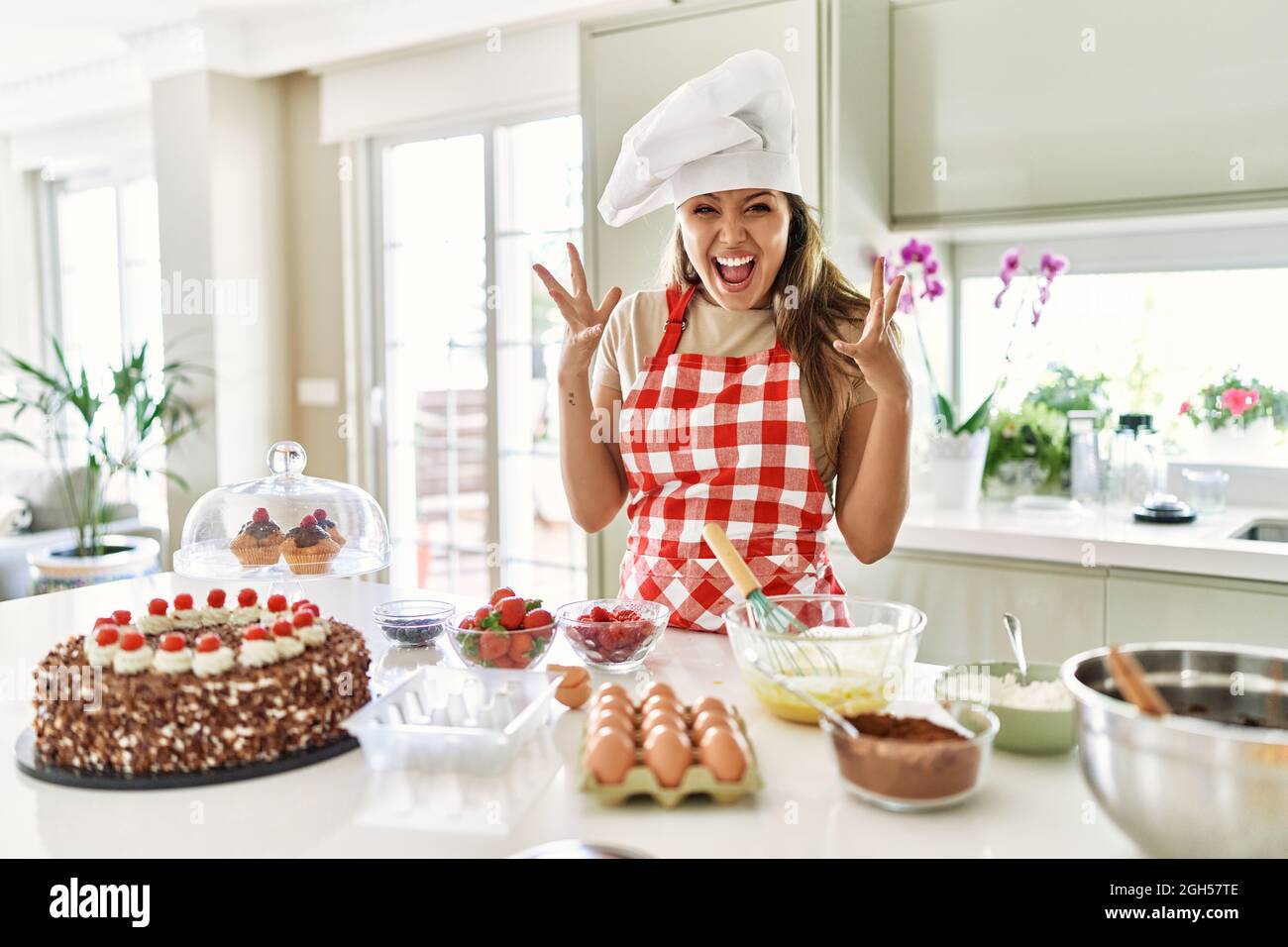 Beautiful young brunette pastry chef woman cooking pastries at the ...