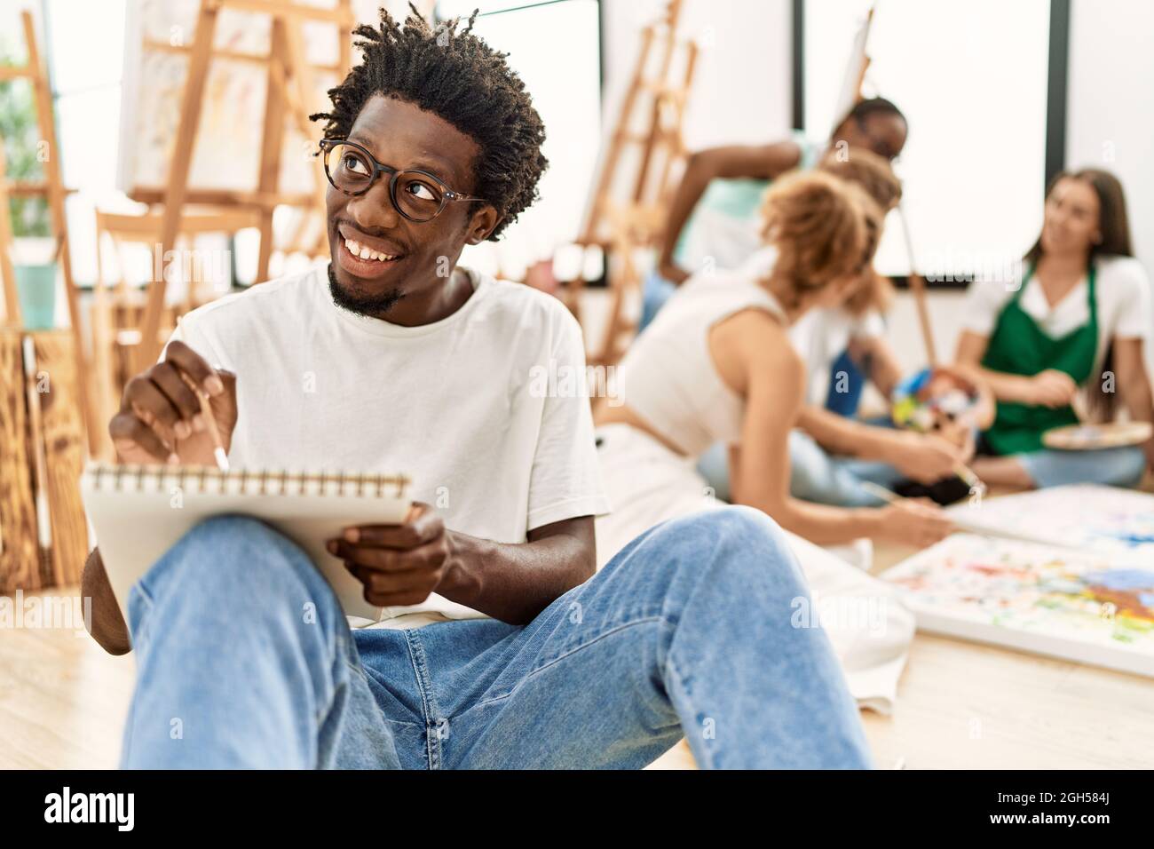 Group of people smiling happy drawing sitting on the floor at art ...