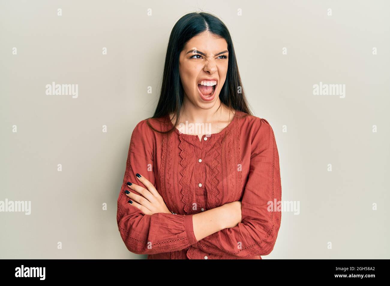 Young hispanic woman wearing casual clothes angry and mad screaming ...
