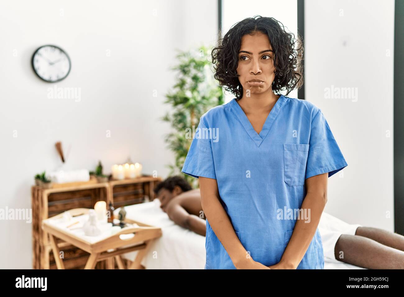 Young therapist woman at wellness spa center depressed and worry for ...