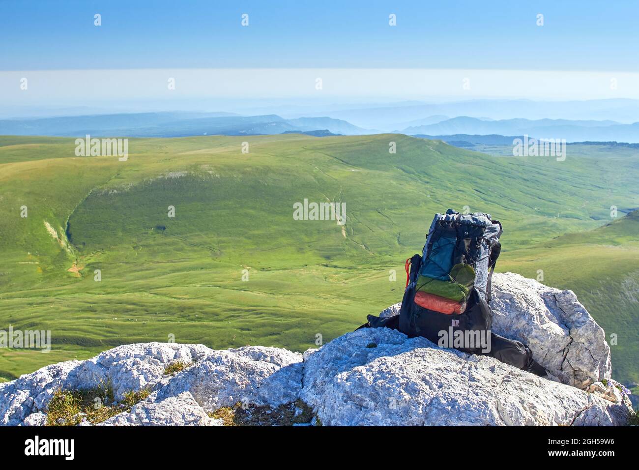 The backpack is lying on the rocks in the mountains against the ...