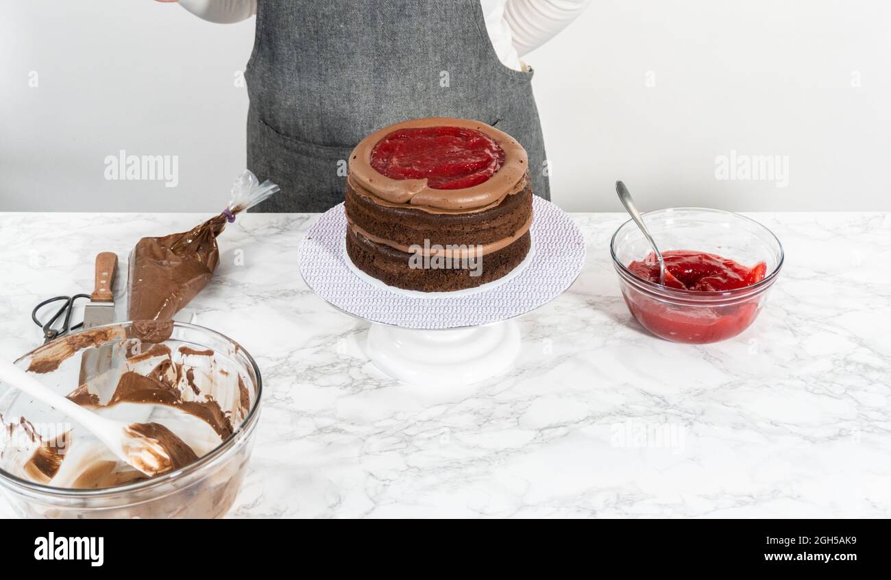 Covering chocolate cake with a crumb layer of chocolate buttercream ...