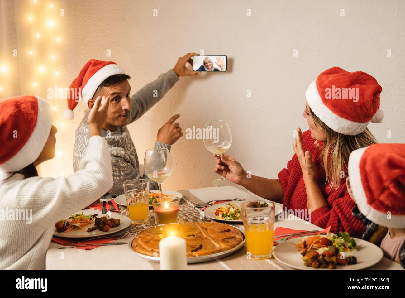 Happy family doing Christmas video call party with senior grandmother ...