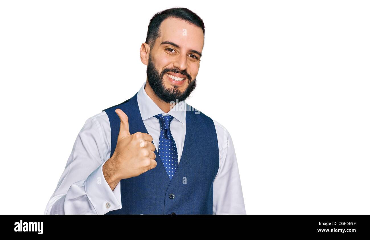 Young man with beard wearing business vest doing happy thumbs up ...