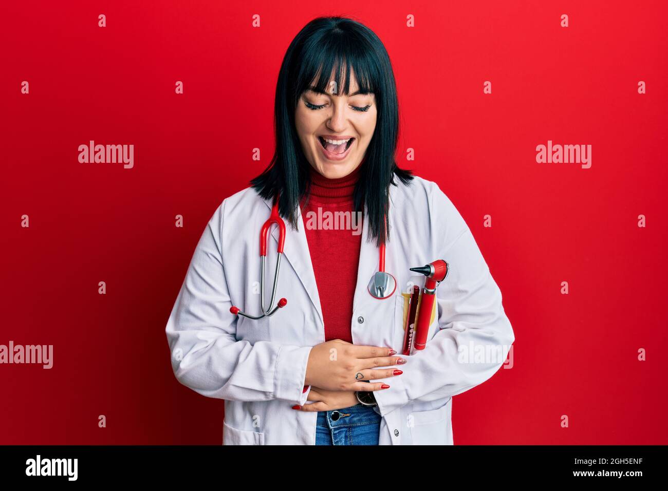 Young hispanic woman wearing doctor uniform and stethoscope smiling and ...