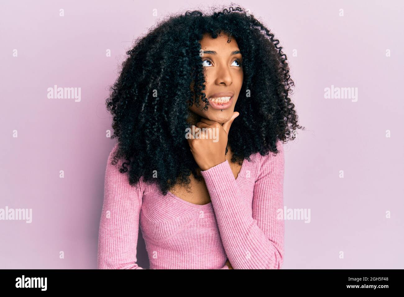 African american woman with afro hair wearing casual pink shirt with ...