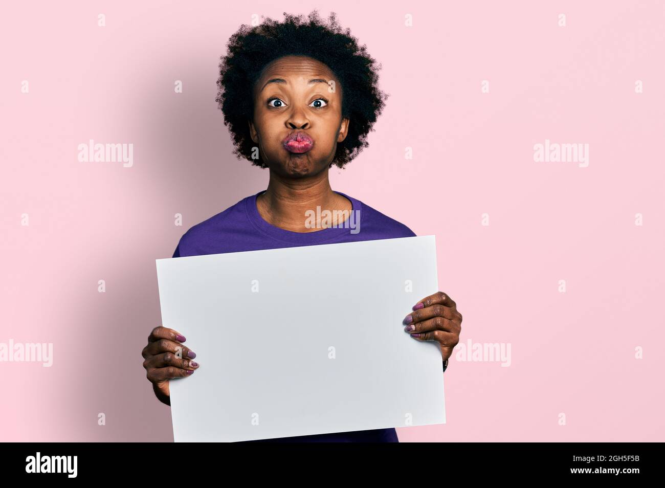 African american woman with afro hair holding blank empty banner ...