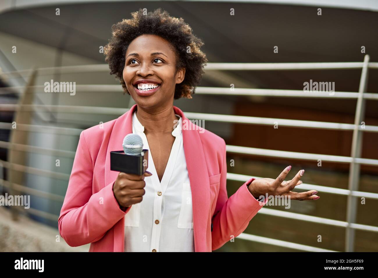 Young african american woman journalist holding reporter microphone ...