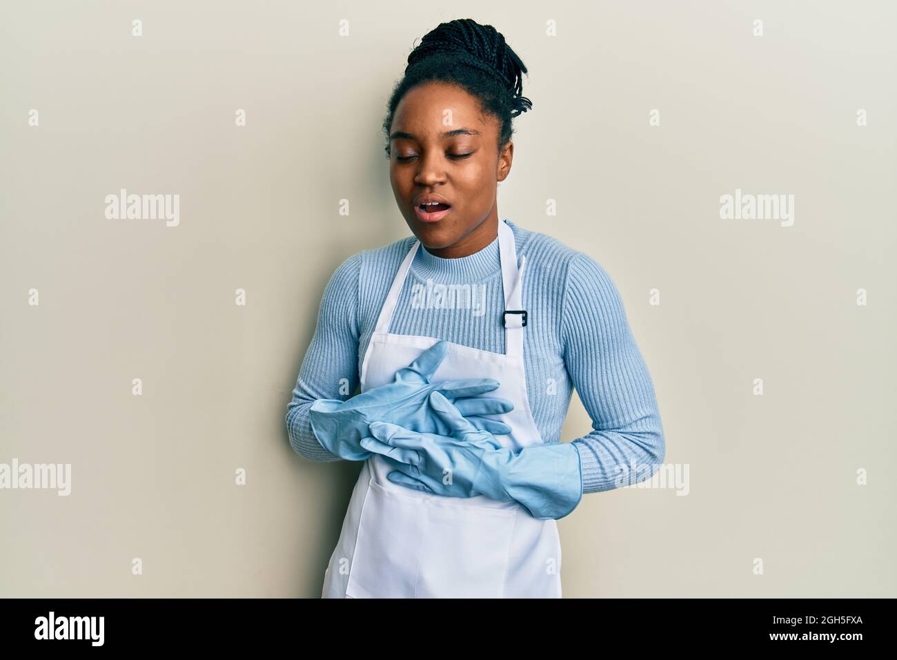 African american woman with braided hair wearing cleaner apron and ...