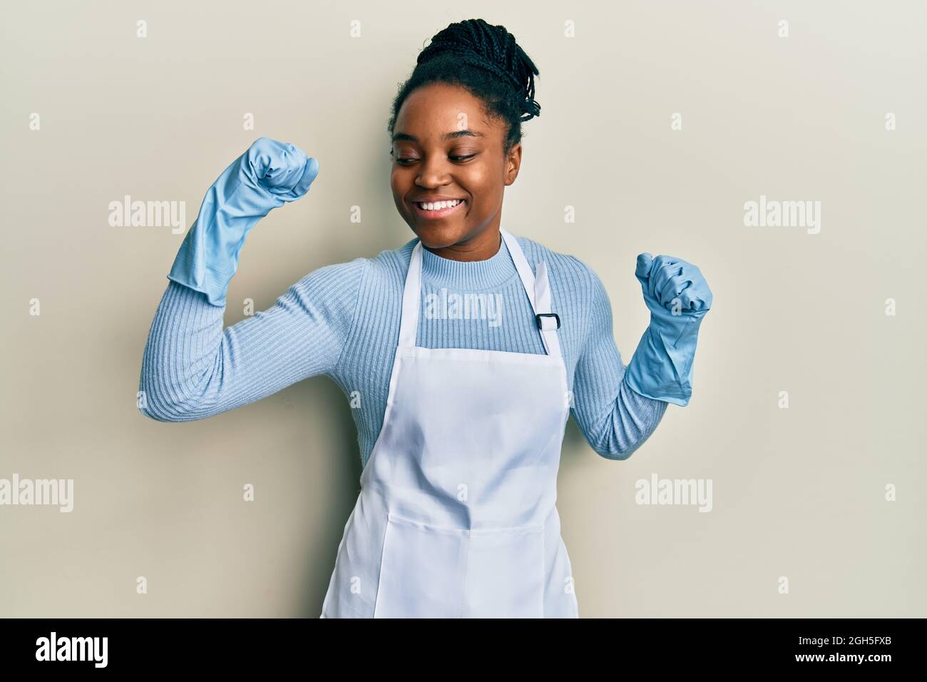 African american woman with braided hair wearing cleaner apron and ...
