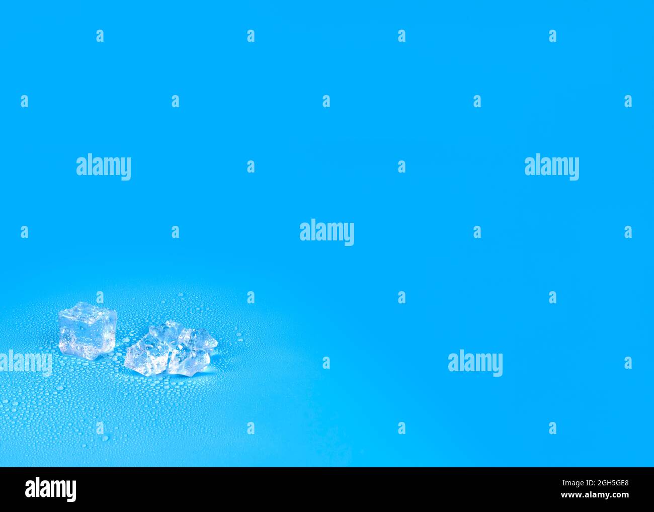 Melting ice cubes on a blue background, one whole ice cube and broken ...