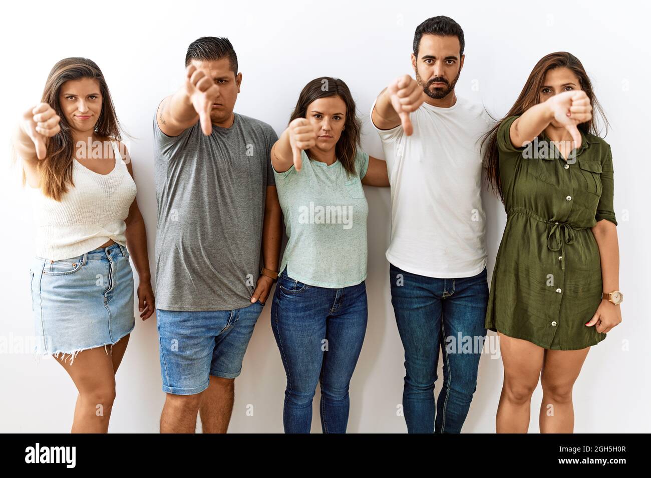 Group of young hispanic friends standing together over isolated ...