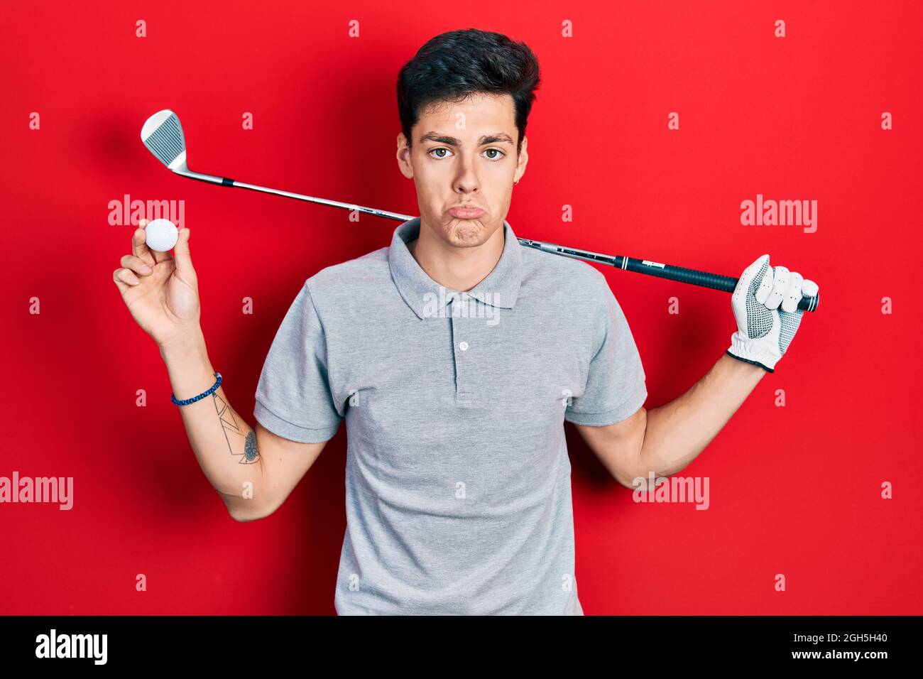 Young hispanic man holding golf ball depressed and worry for distress ...