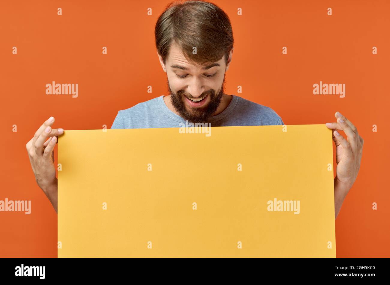 funny man holding a yellow banner design orange background Stock Photo ...