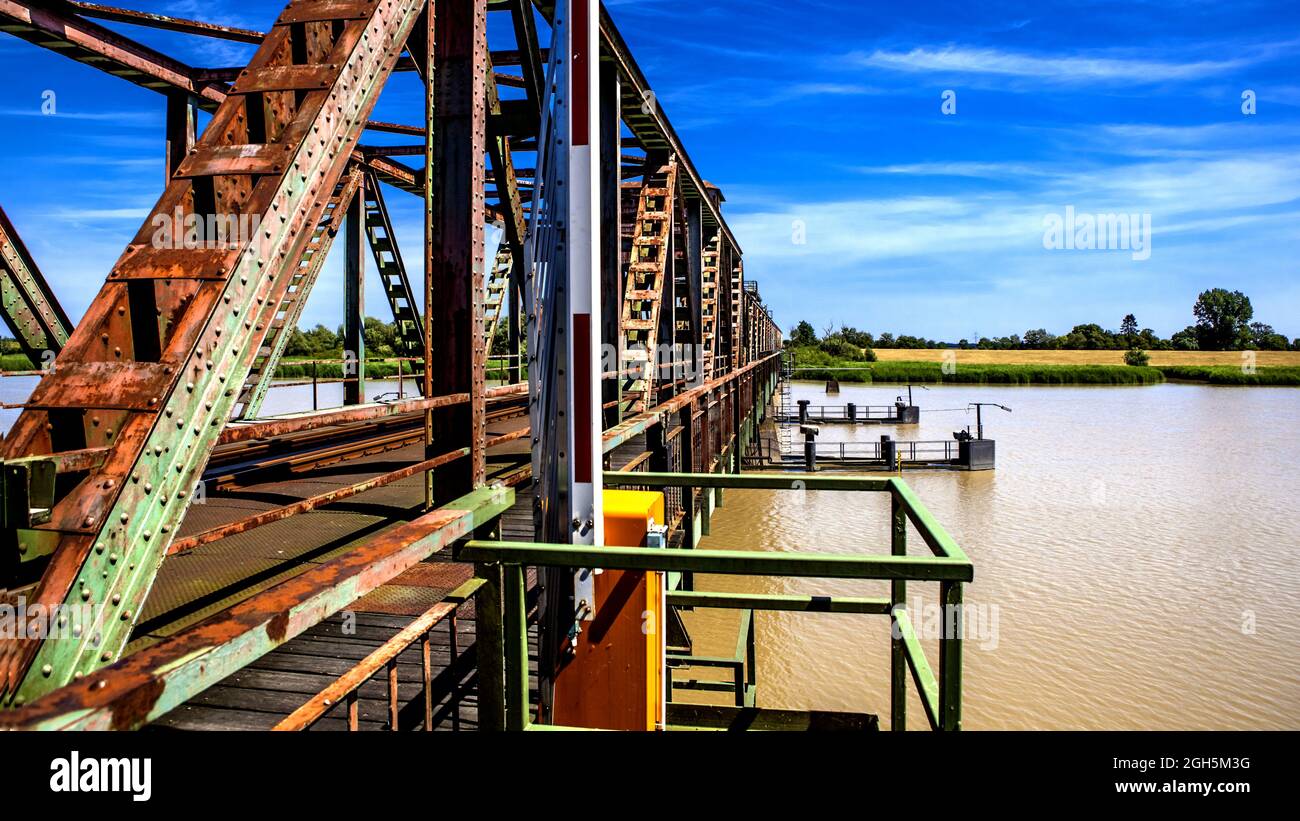 An old rusty girder bridge over a dirty river under the sunlight Stock ...