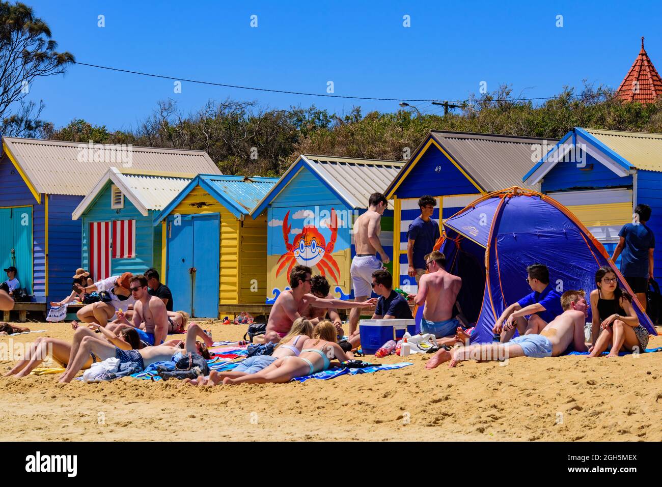 People having fun on the Brighton Beach with colorful Bathing Boxes as ...