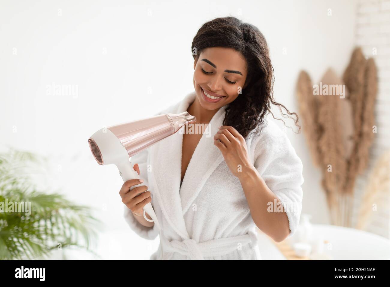 Cheerful African American Lady Drying Hair Using Blowdryer In Bathroom ...