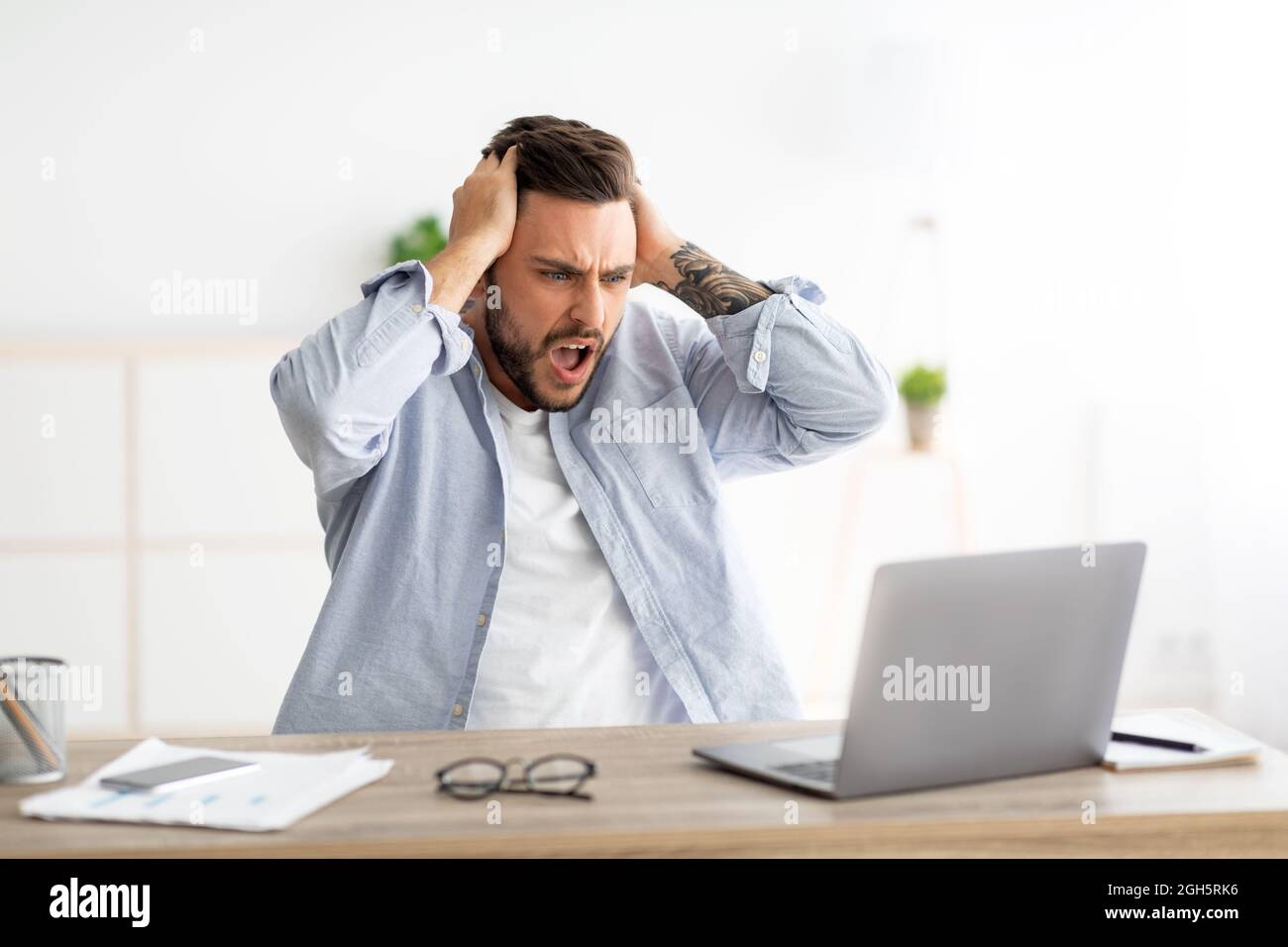 Angry man having software, website error, looking at laptop screen and ...