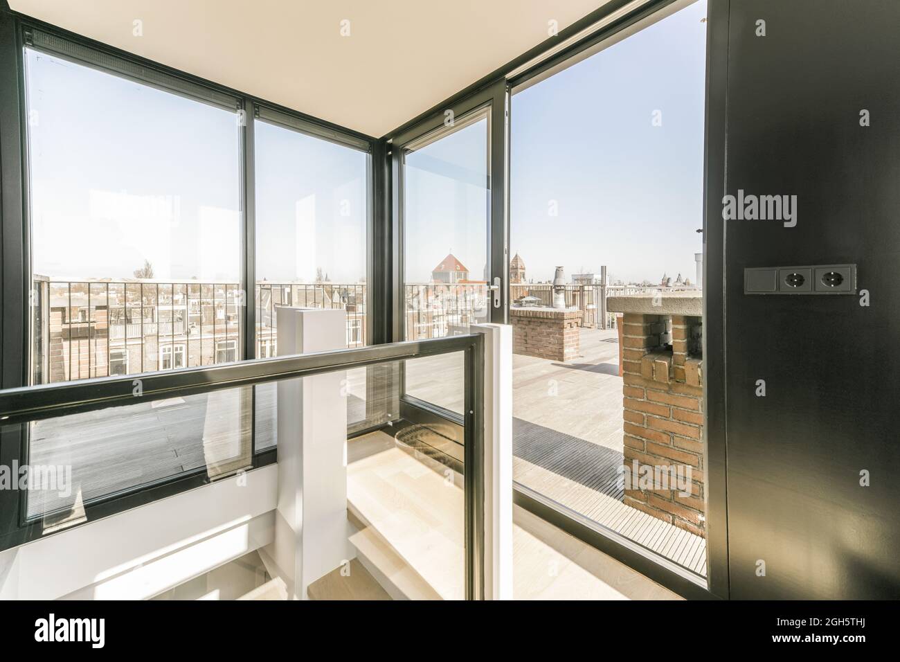 Through huge windows of flat view of spacious terrace lit by sunlight ...