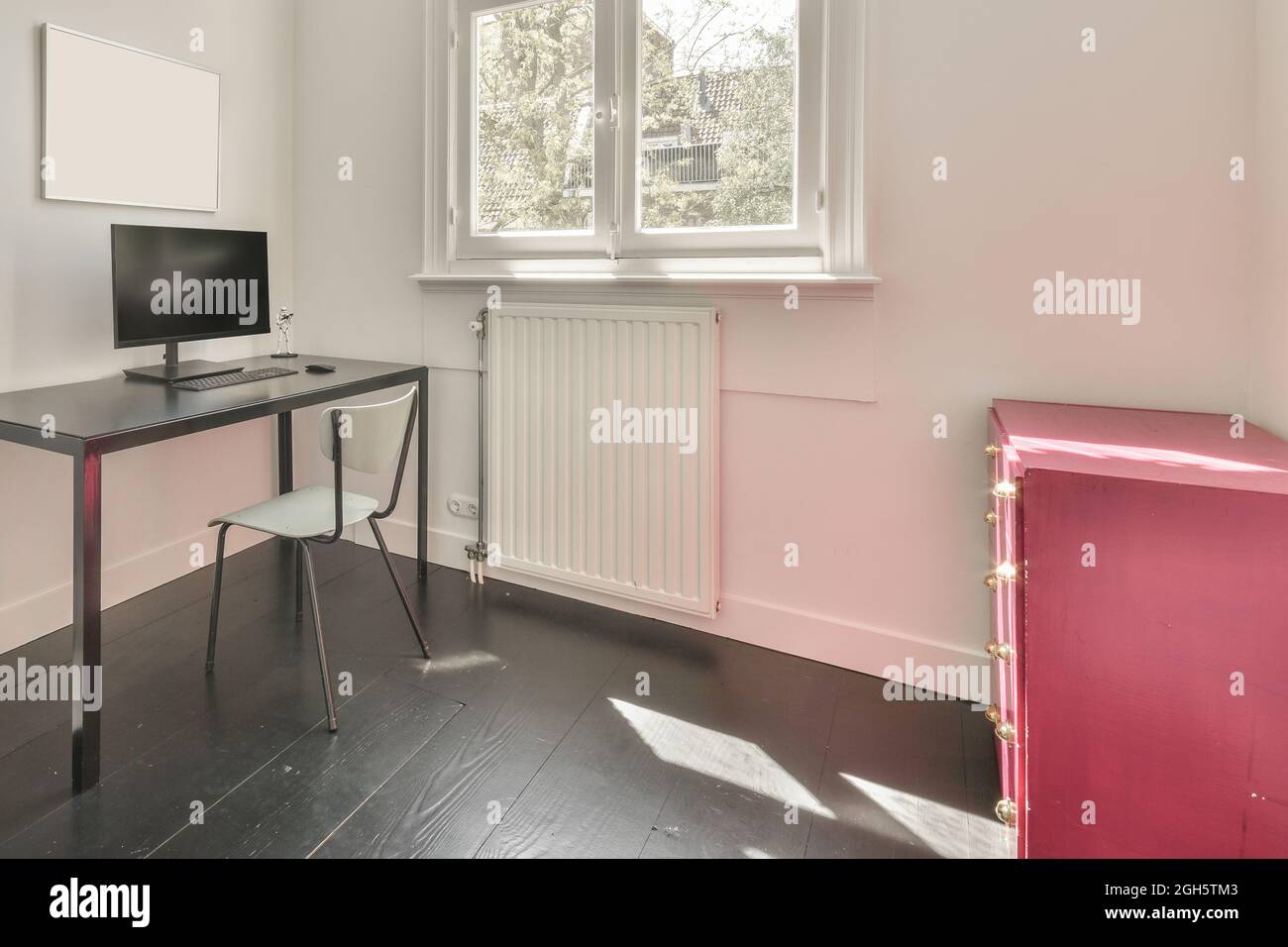 Simple table with computer monitor and chair placed near wall with ...
