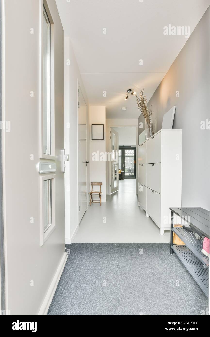 Perspective view of hallway with minimalist white furniture and ...