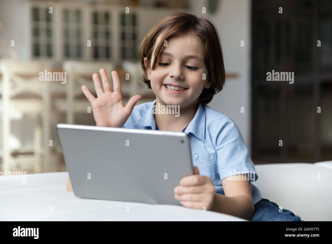 Smiling little kid boy holding video call using digital tablet Stock ...