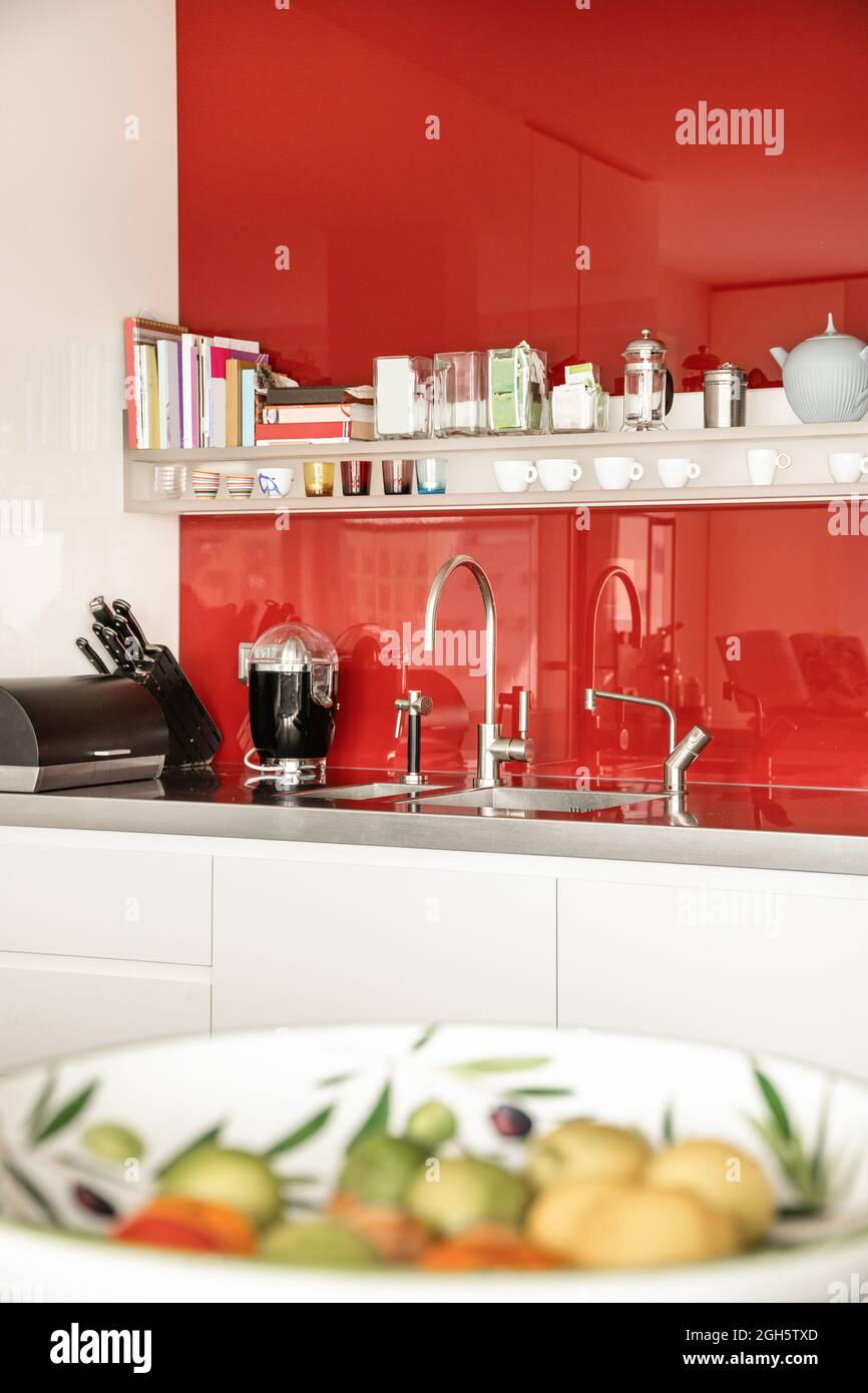 Interior design of modern home kitchen with bright red splashback and ...