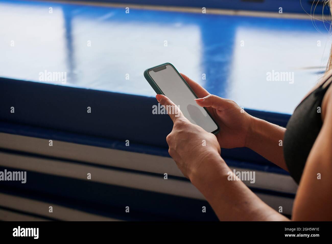 Side view of crop unrecognizable female athlete in bra surfing Internet ...
