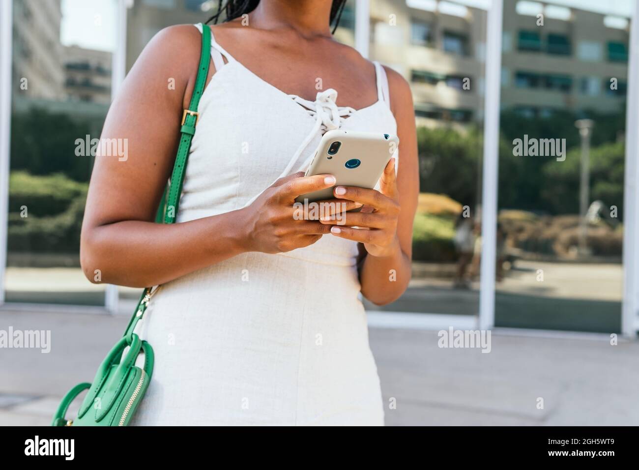 Low angle of anonymous African American female with brads messaging on ...