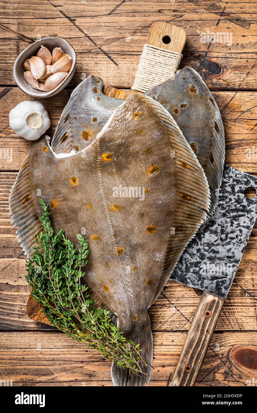 Raw flounder flatfish on butcher board with cleaver. wooden background ...