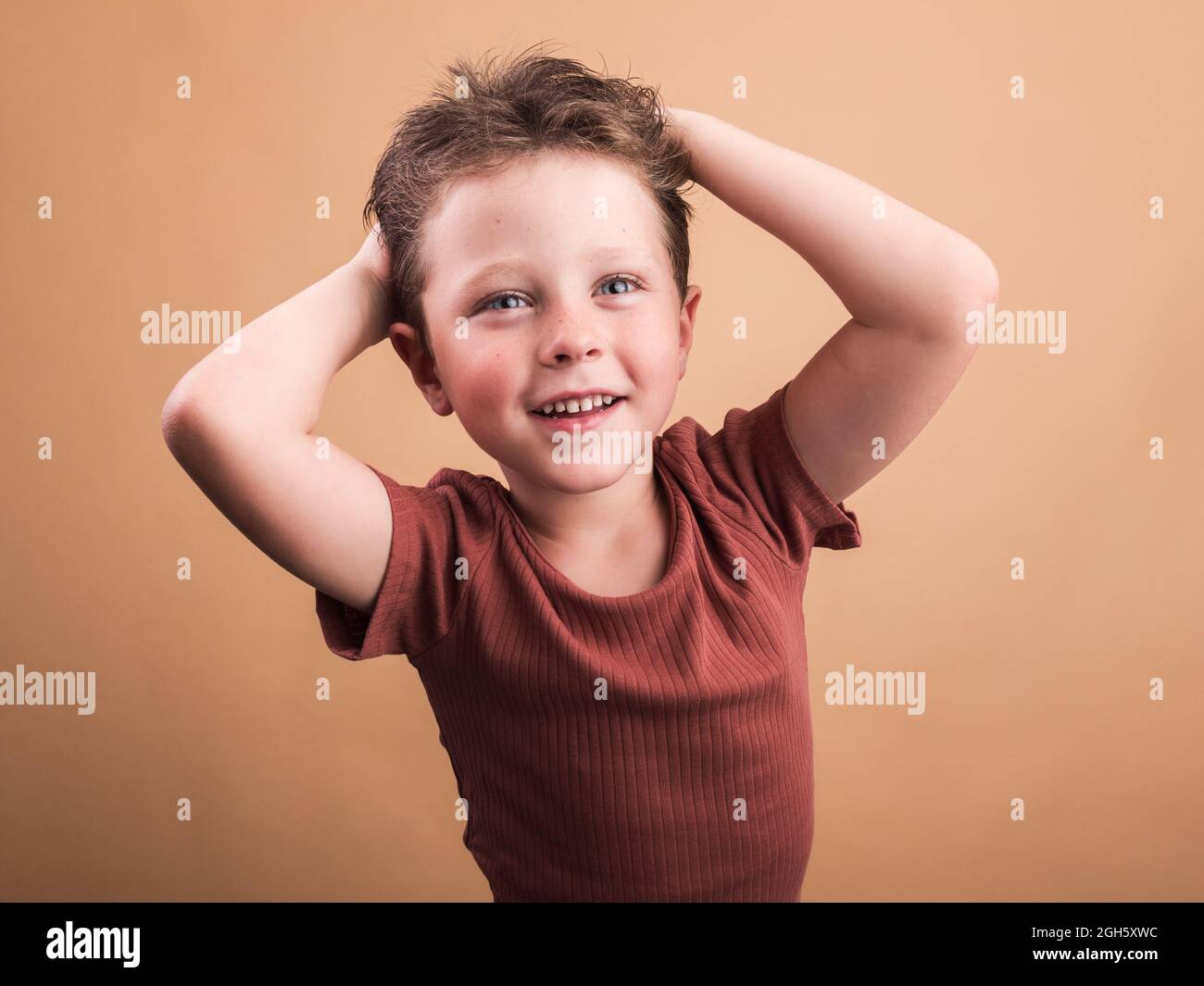 Satisfied child in casual clothes with brown hair looking away with ...