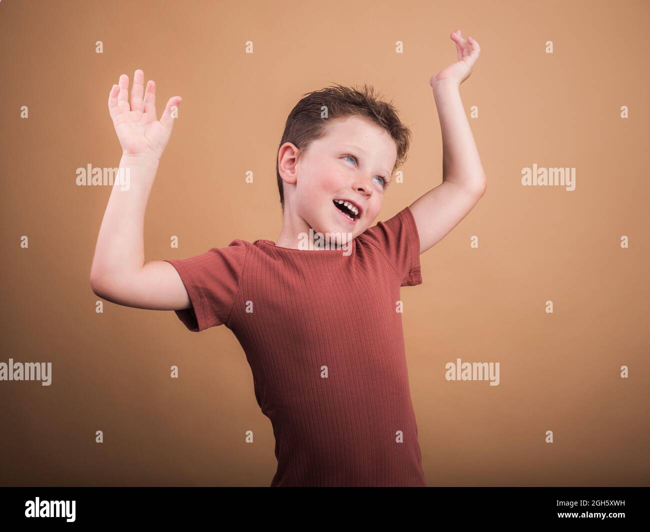 Satisfied child in casual clothes with brown hair looking away with ...
