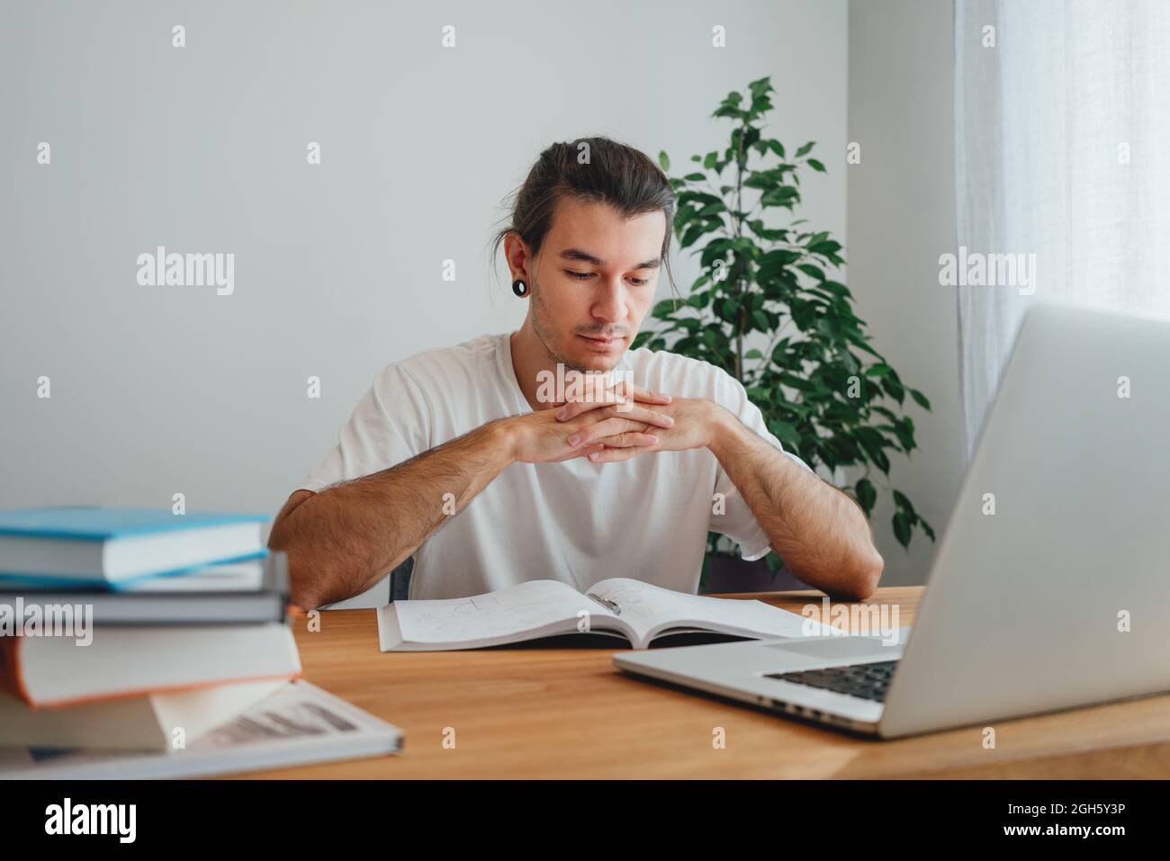 University student studying and making notes at campus. Adult student ...