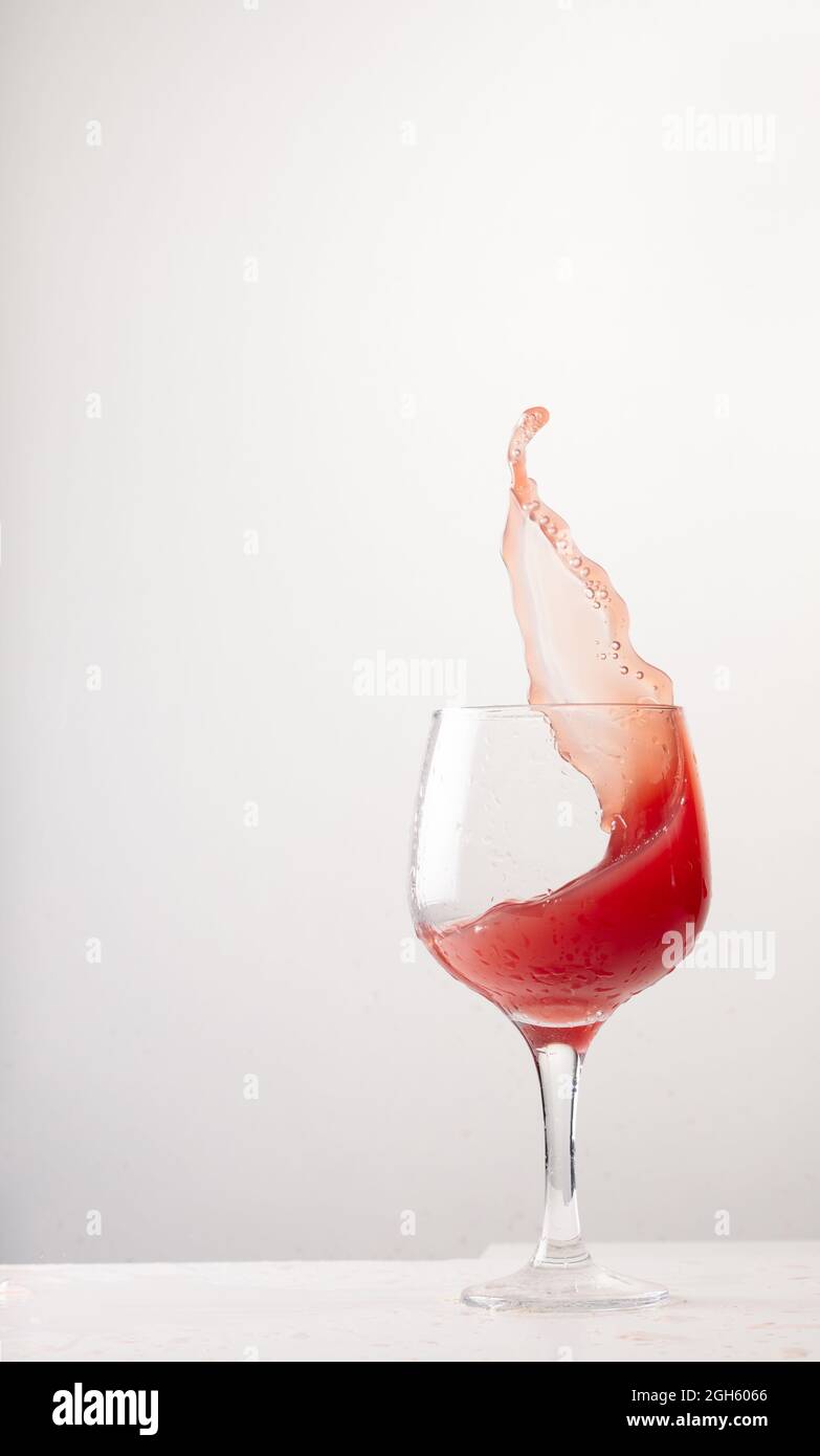 Crystal shiny glass with alcohol pink splashing cocktail on white ...