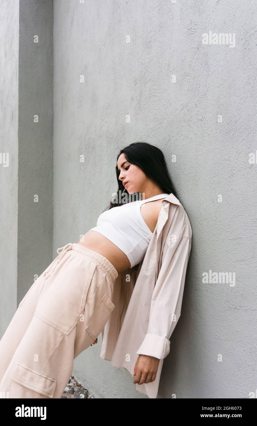 Side view of flexible female dancer leaning on wall and showing ...