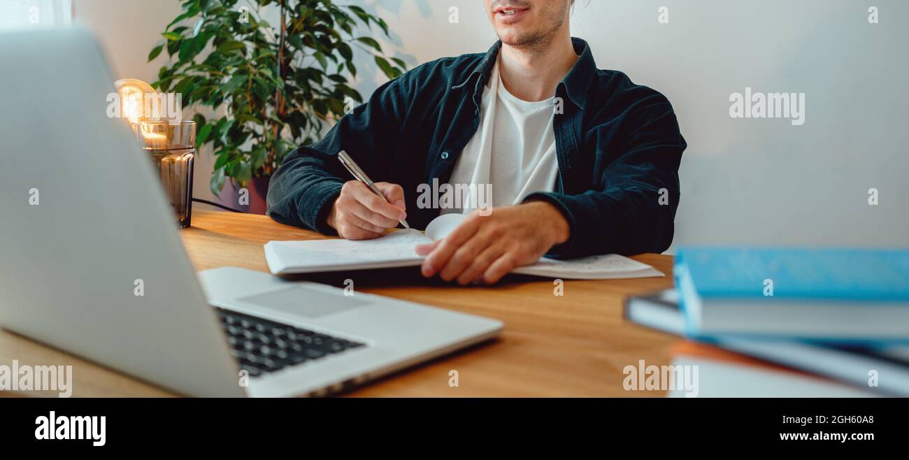 University student studying and making notes at campus. Adult student ...