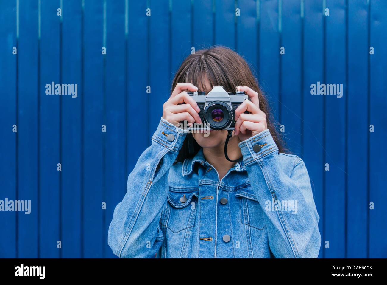 Anonymous female photographer in denim jacket taking picture on vintage ...