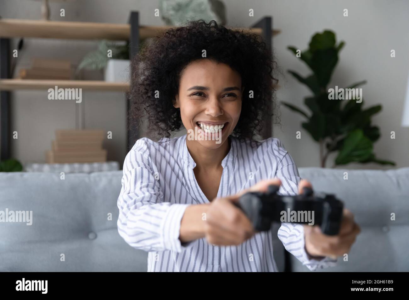 Overjoyed african gen z female holding gamepad gaming on console Stock ...