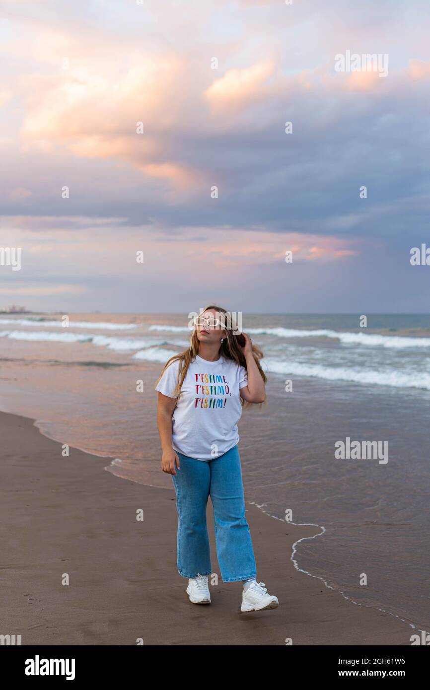 Back view of slim female in bikini practicing yoga on poolside of ...