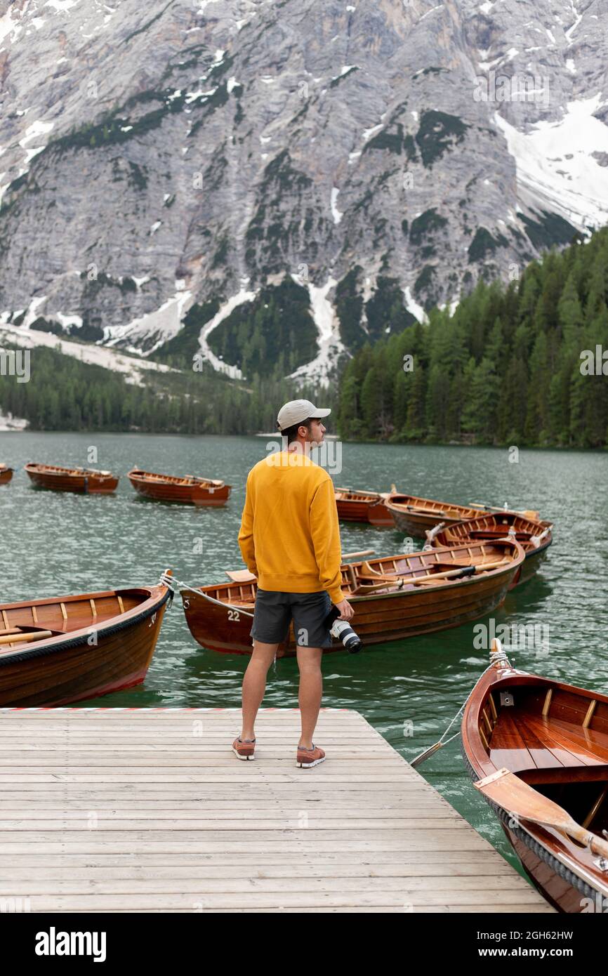 Back view of unrecognizable male explorer photographer holding a ...
