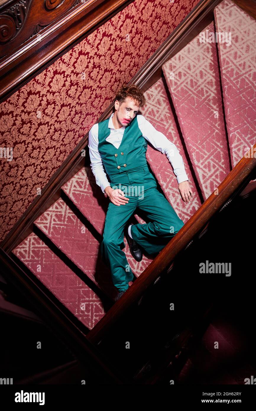 From above of expressive male actor lying on stairs and pretending ...