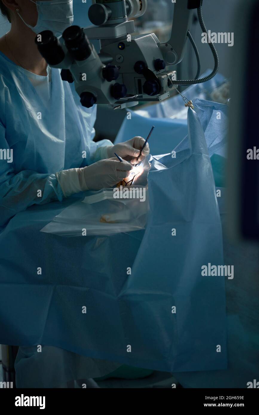 Crop anonymous eye surgeon with manual instruments operating patient on ...